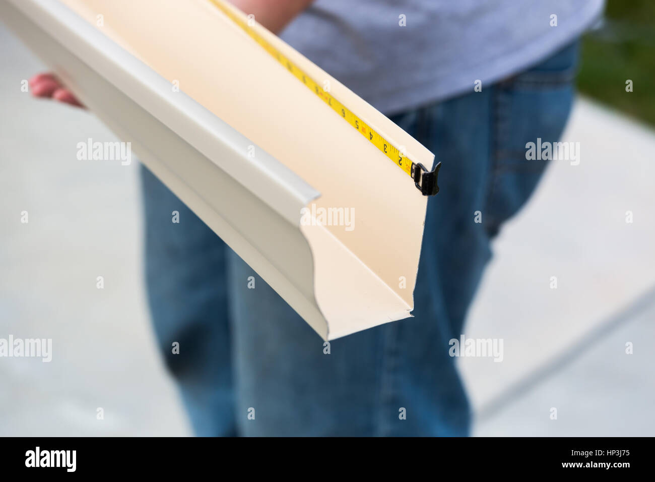 Worker Measuring An Aluminum Rain Gutter Feeding Through Seamless ...