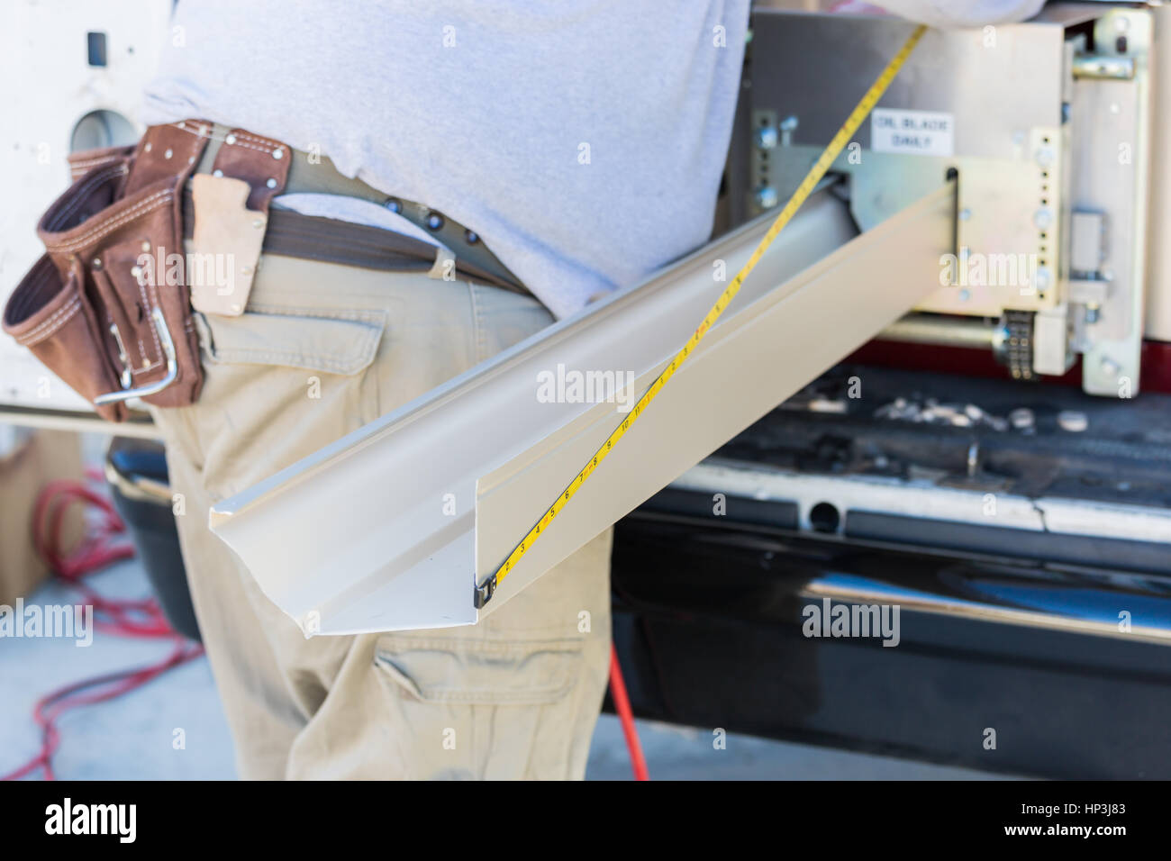 Worker Measuring An Aluminum Rain Gutter Feeding Through Seamless ...