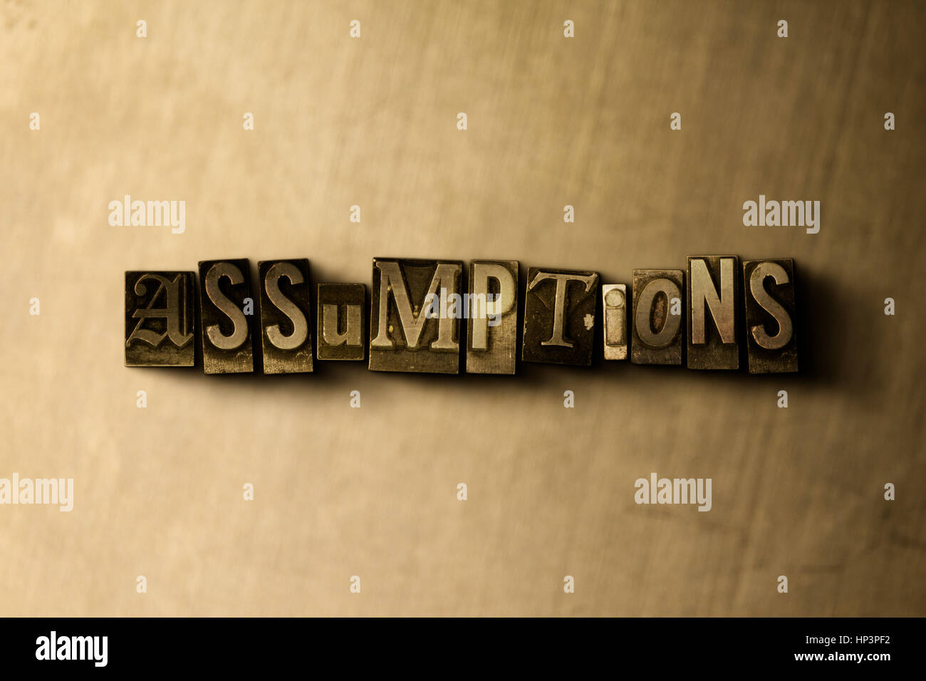 ASSUMPTIONS - close-up of grungy vintage typeset word on metal backdrop ...