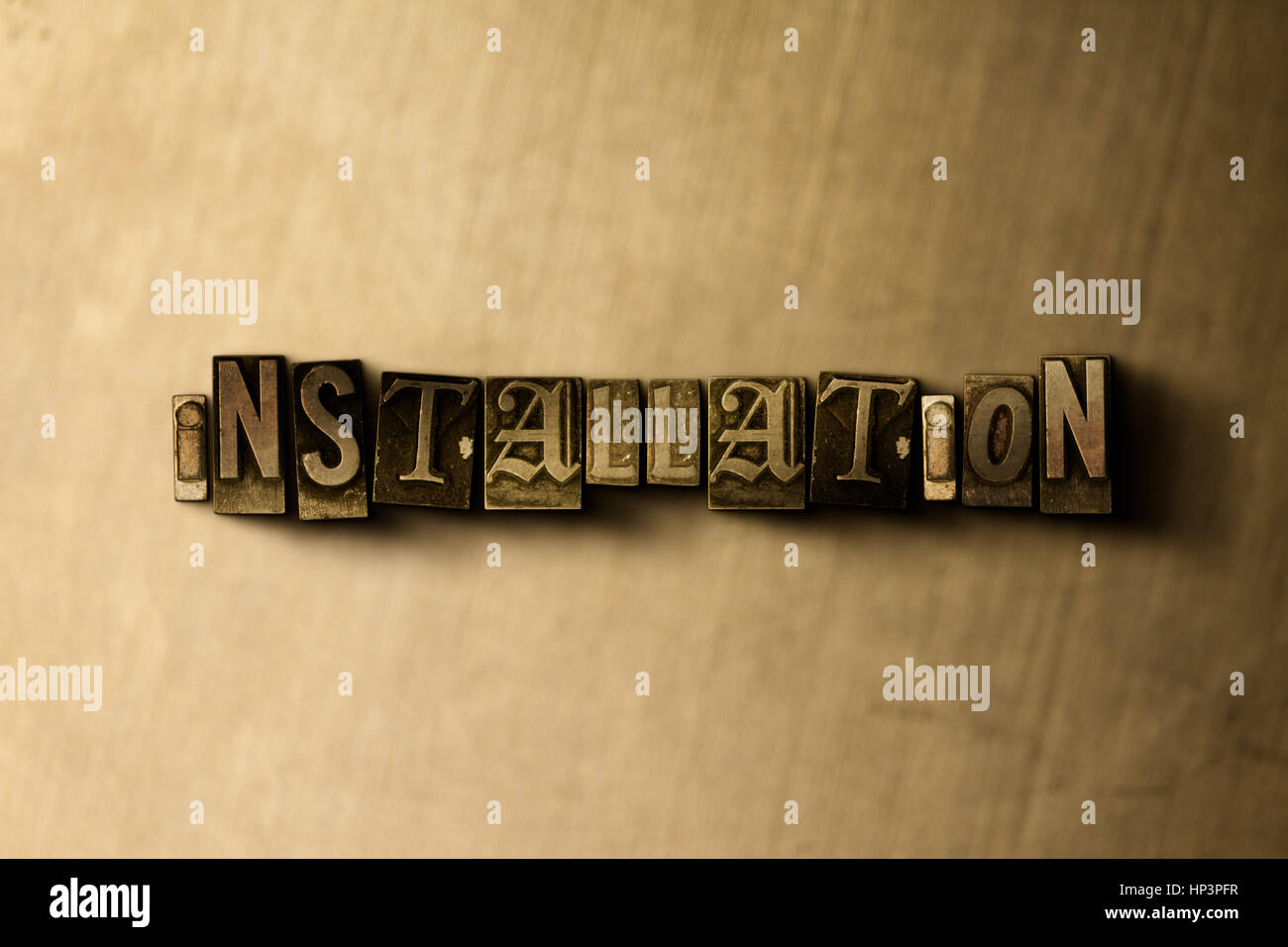 INSTALLATION - close-up of grungy vintage typeset word on metal ...