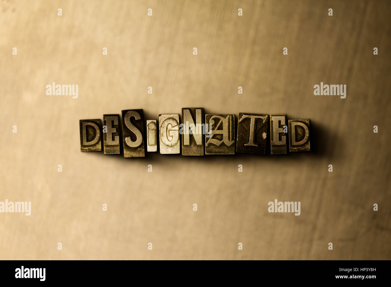 DESIGNATED - close-up of grungy vintage typeset word on metal backdrop ...