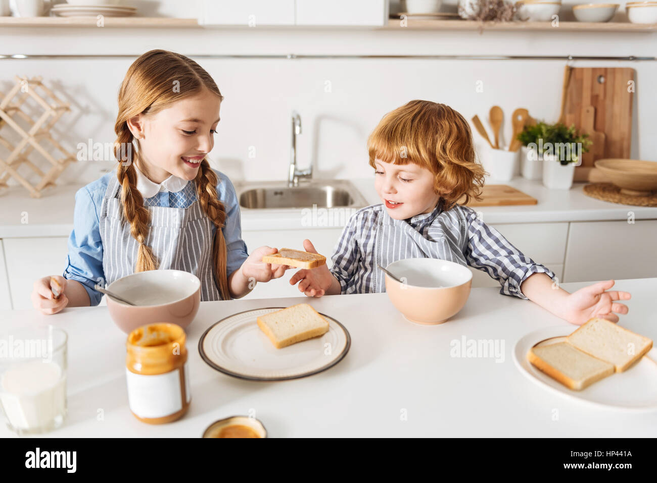 Lovely siblings sharing freshly made sandwiches Stock Photo - Alamy
