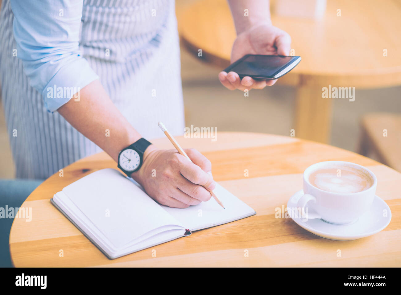 Pleasant waiter making notes Stock Photo - Alamy