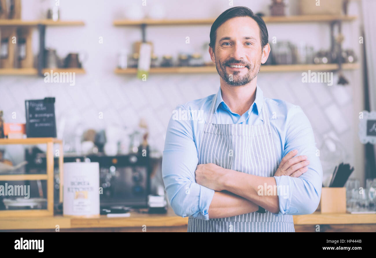 Positive professional cafe owner welcoming guests Stock Photo - Alamy