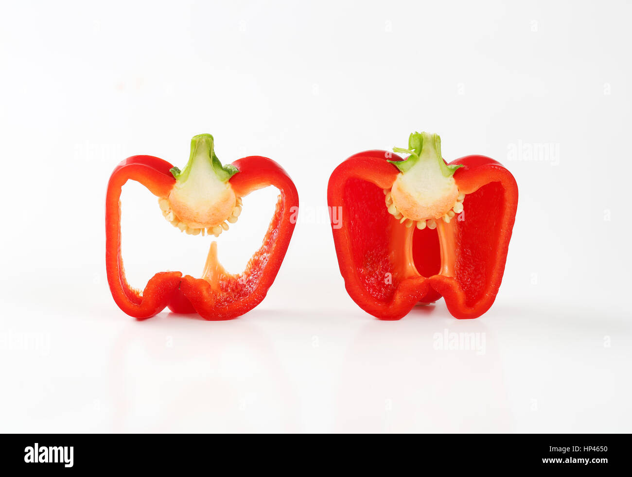 red pepper halved and sliced on white background Stock Photo - Alamy