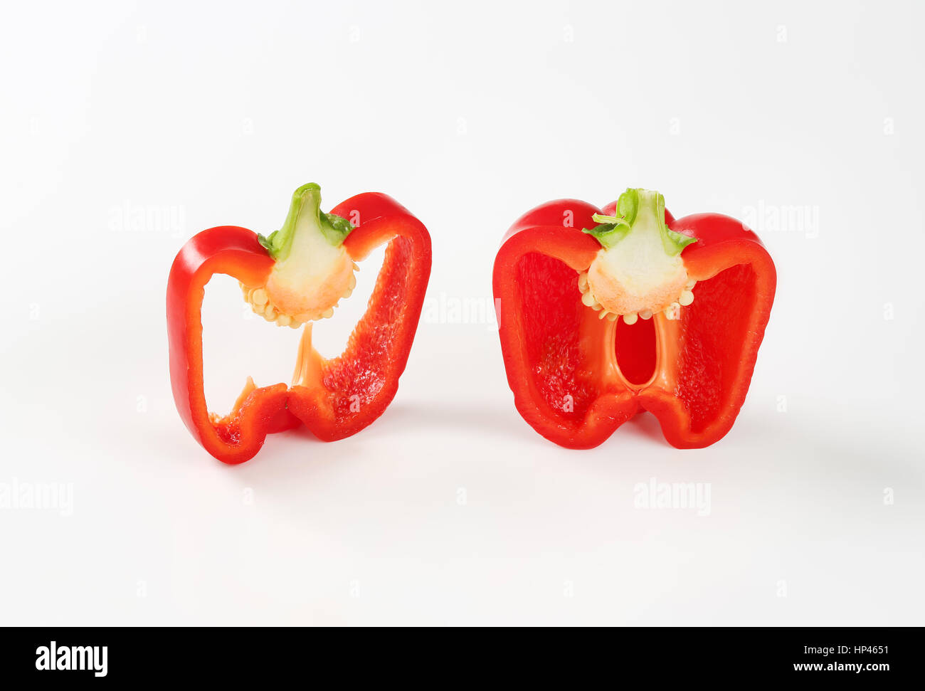 red pepper halved and sliced on white background Stock Photo - Alamy