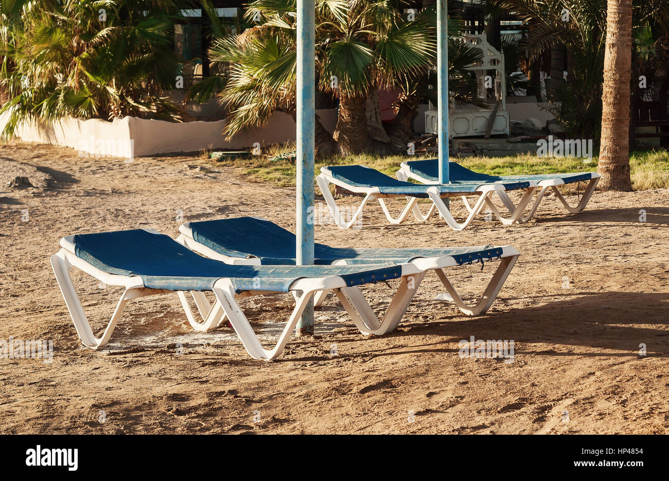 at sunset on the beach Two blue sunbeds Stock Photo - Alamy