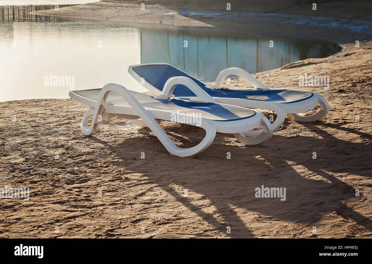 at sunset on the beach Two blue sunbeds Stock Photo - Alamy
