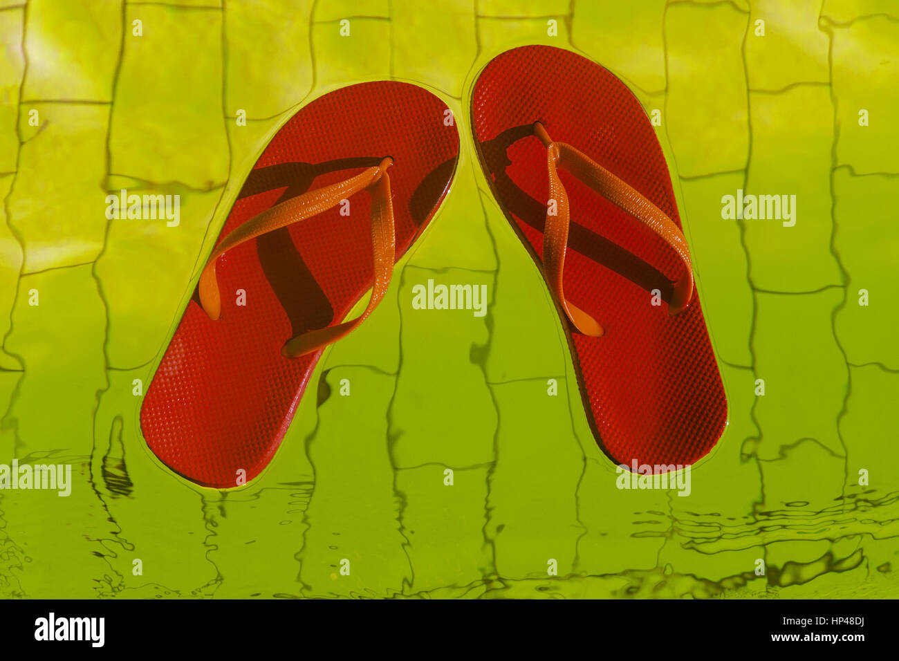 red flip-flops floating in a pool of yellow water, top view Stock Photo ...