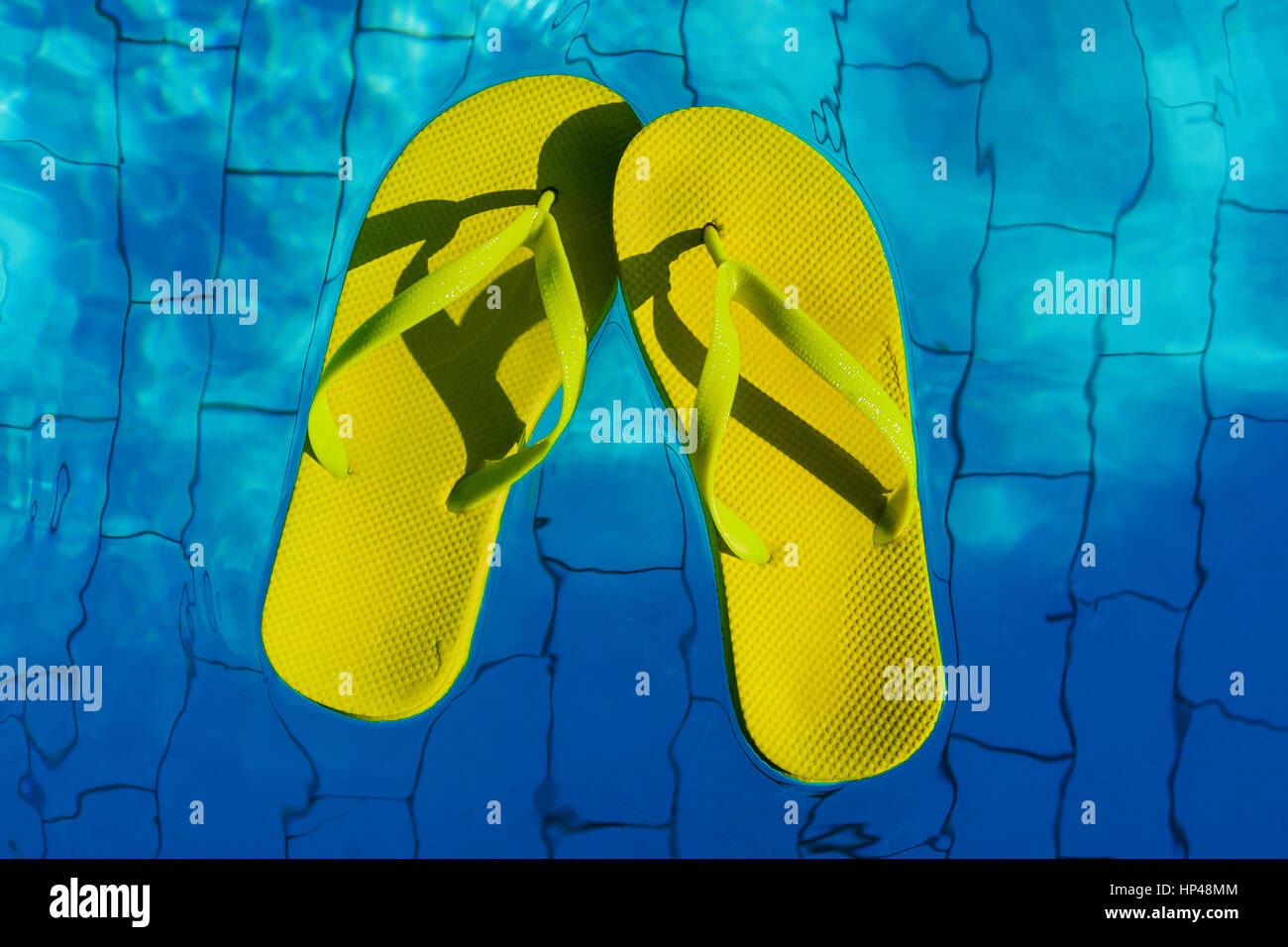 yellow flip-flops floating in a swimming pool, a top view Stock Photo ...
