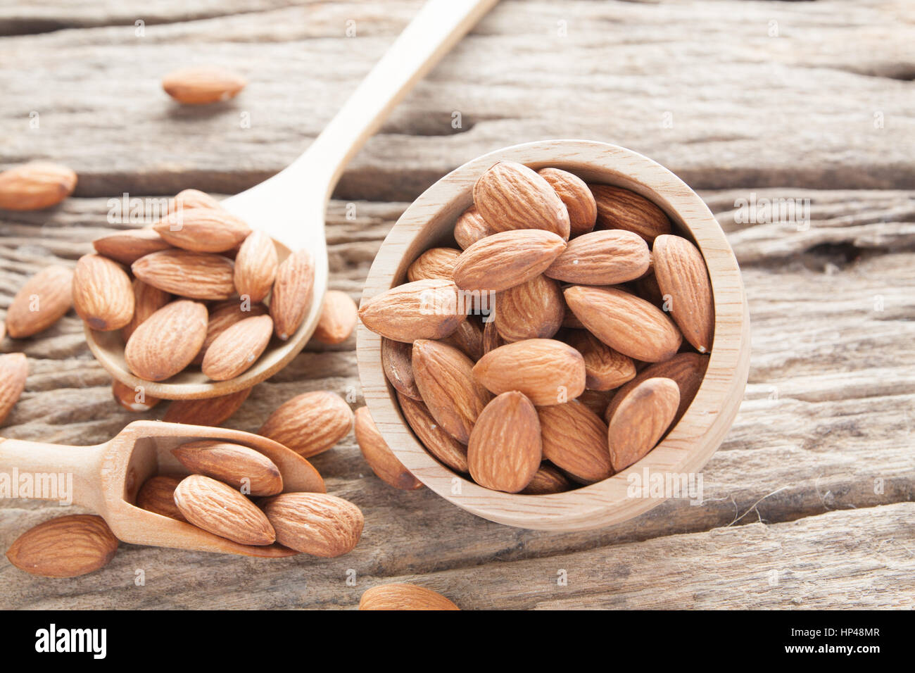 group of almonds from wood bowl on wood background Stock Photo - Alamy