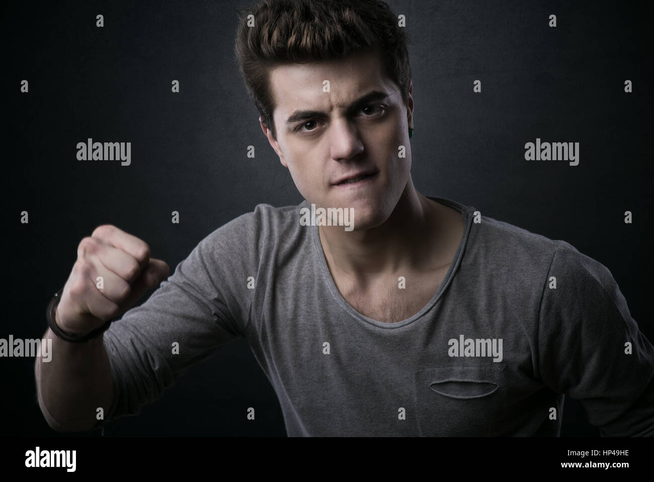 Young aggressive man showing fists and looking at camera Stock Photo ...