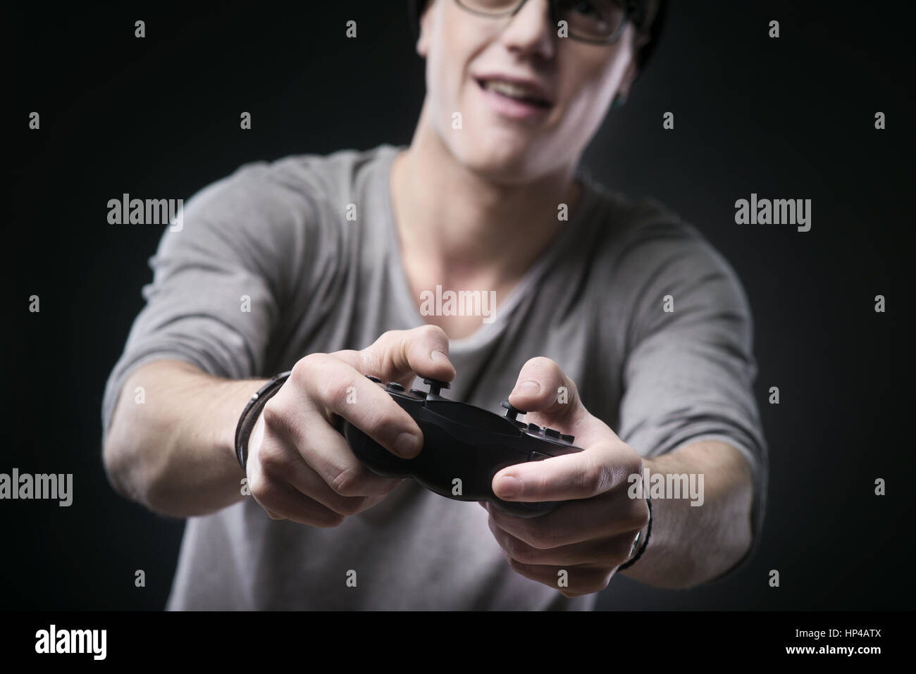 Smiling nerd teenager holding video game controller and playing Stock ...