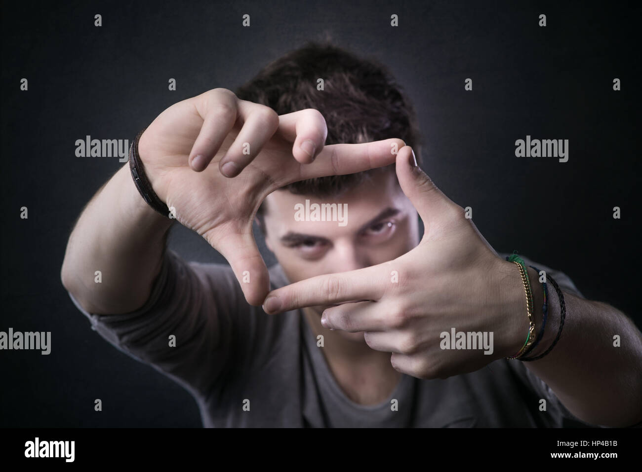 Young handsome flirty man making a frame with his fingers around his ...