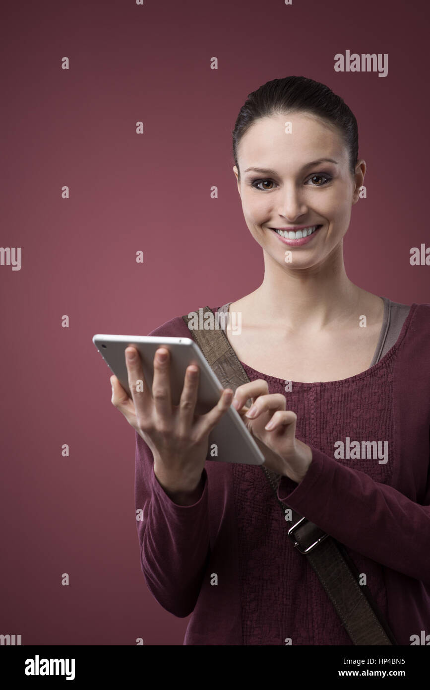 Female smiling student using a digital touch screen tablet Stock Photo ...