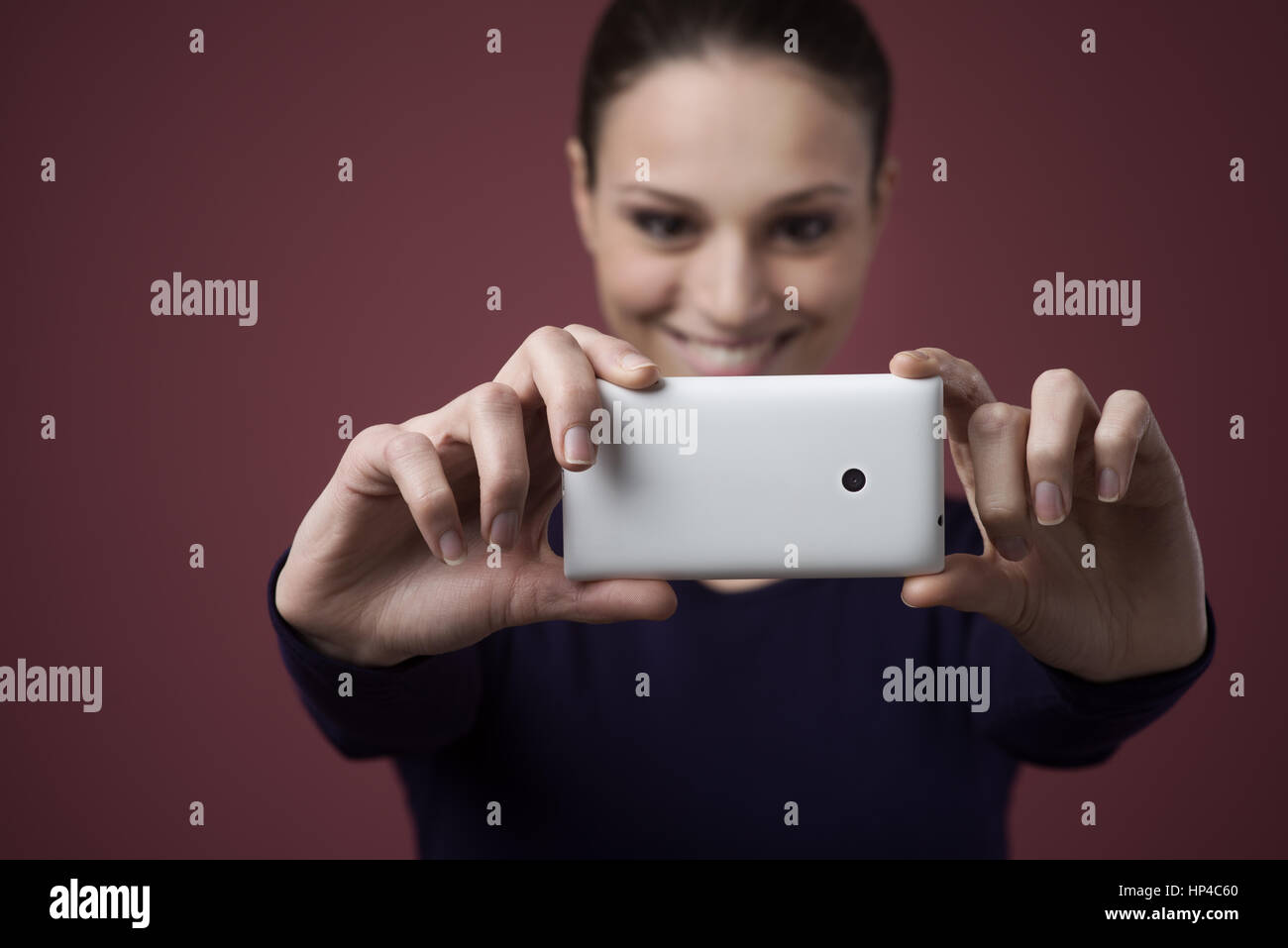 Young smiling woman taking a self portrait with her mobile phone Stock ...