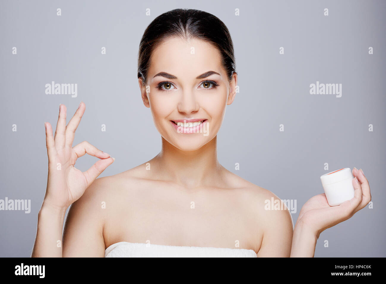 Girl holding cream and showing okay Stock Photo - Alamy