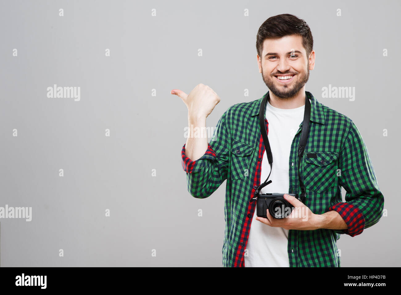 Man holding camera and pointing aside Stock Photo - Alamy