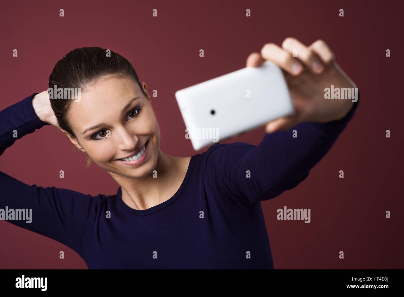 Young smiling woman taking a self portrait with her mobile phone Stock ...