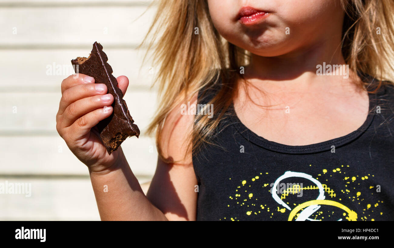 little girl eats tasty chocolate Stock Photo - Alamy