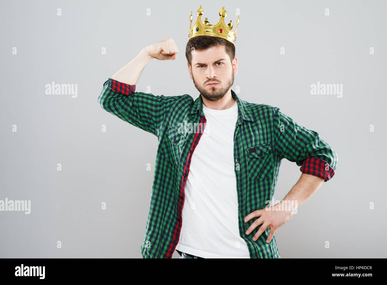 Frowning man in crown showing strength Stock Photo - Alamy