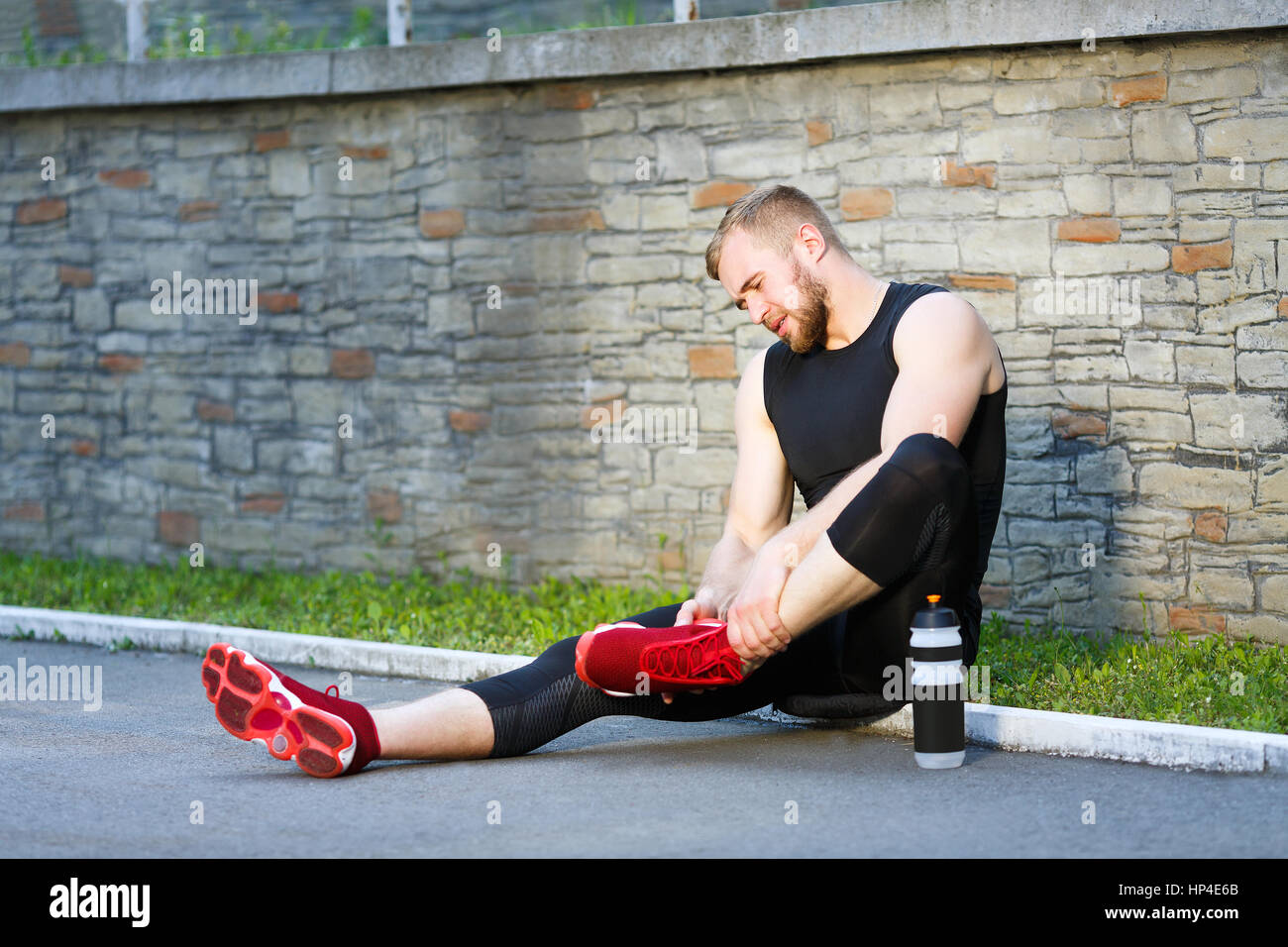 Sportsman limbering up his leg Stock Photo - Alamy