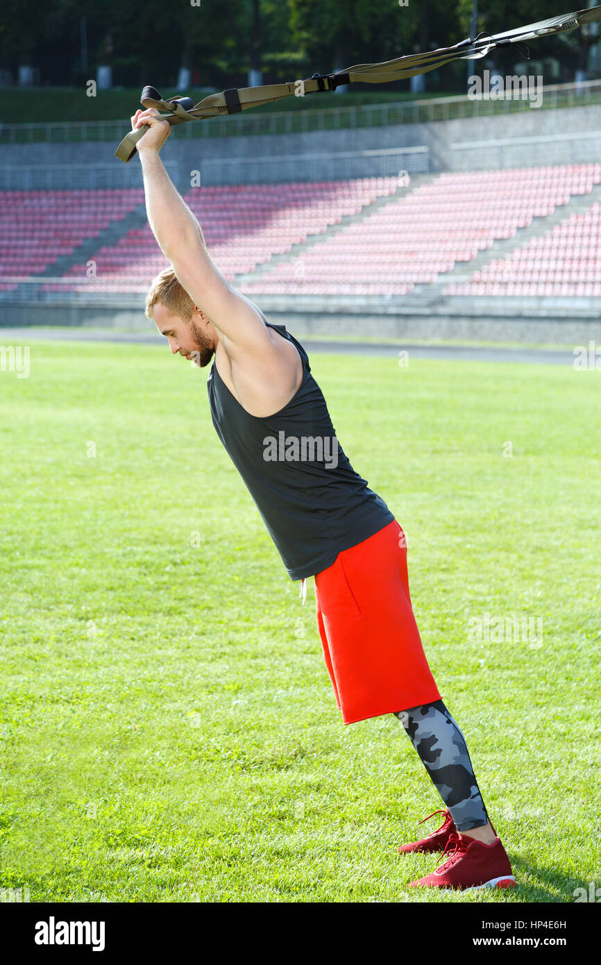 Full body of man training with training loop Stock Photo - Alamy