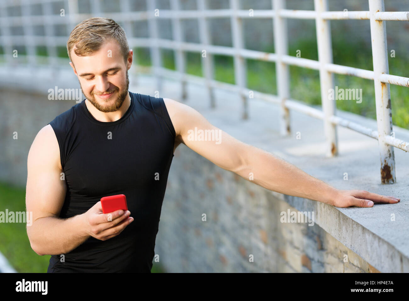 Man standing with red mobile phone and smiling Stock Photo - Alamy