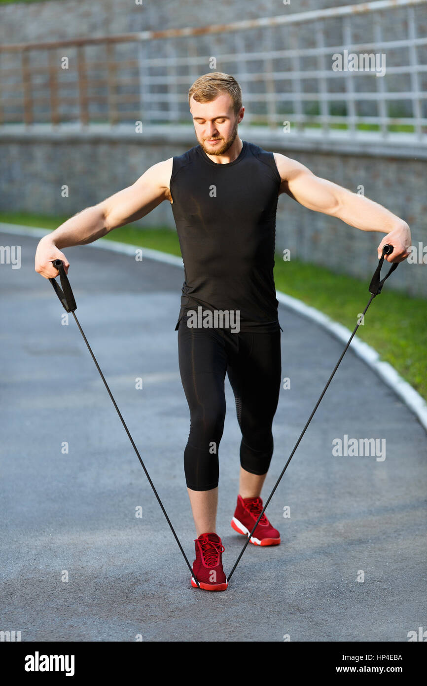 Man standing on expander with one leg Stock Photo - Alamy