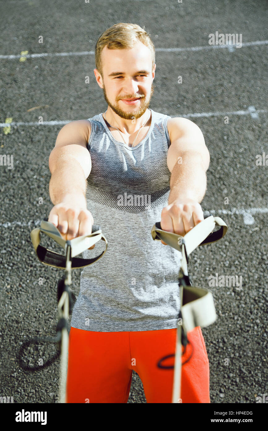 Handsome man doing exercises at stadium Stock Photo - Alamy