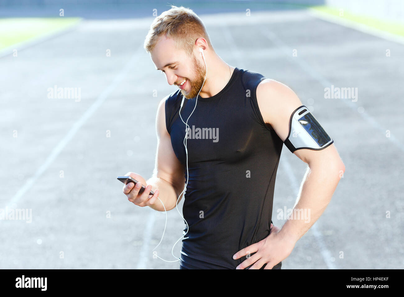 Man listening to music on running track Stock Photo - Alamy