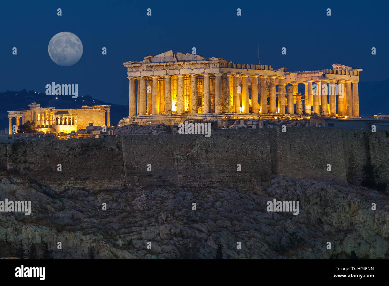 The Parthenon in Acropolis Hill in Athens, Greece shot in blue hour with the moon rising above ...