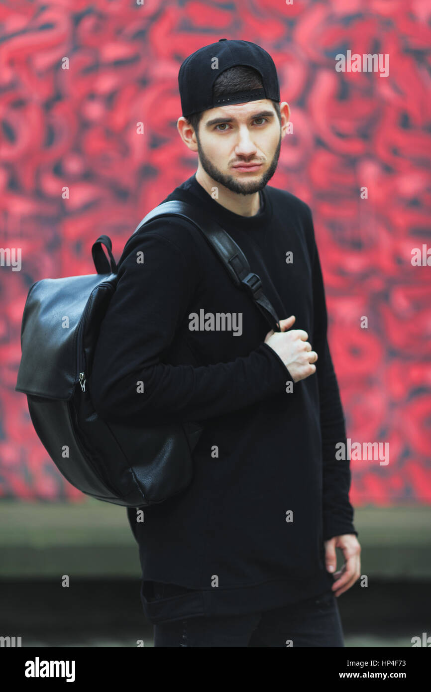 Young man standing near colorful wall Stock Photo - Alamy
