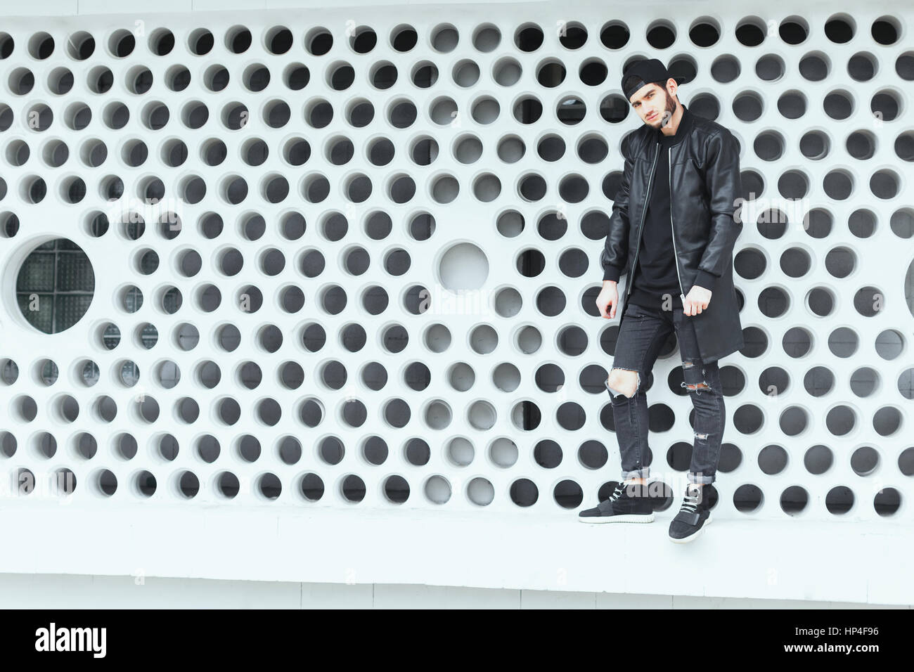 Young man standing near wall Stock Photo - Alamy