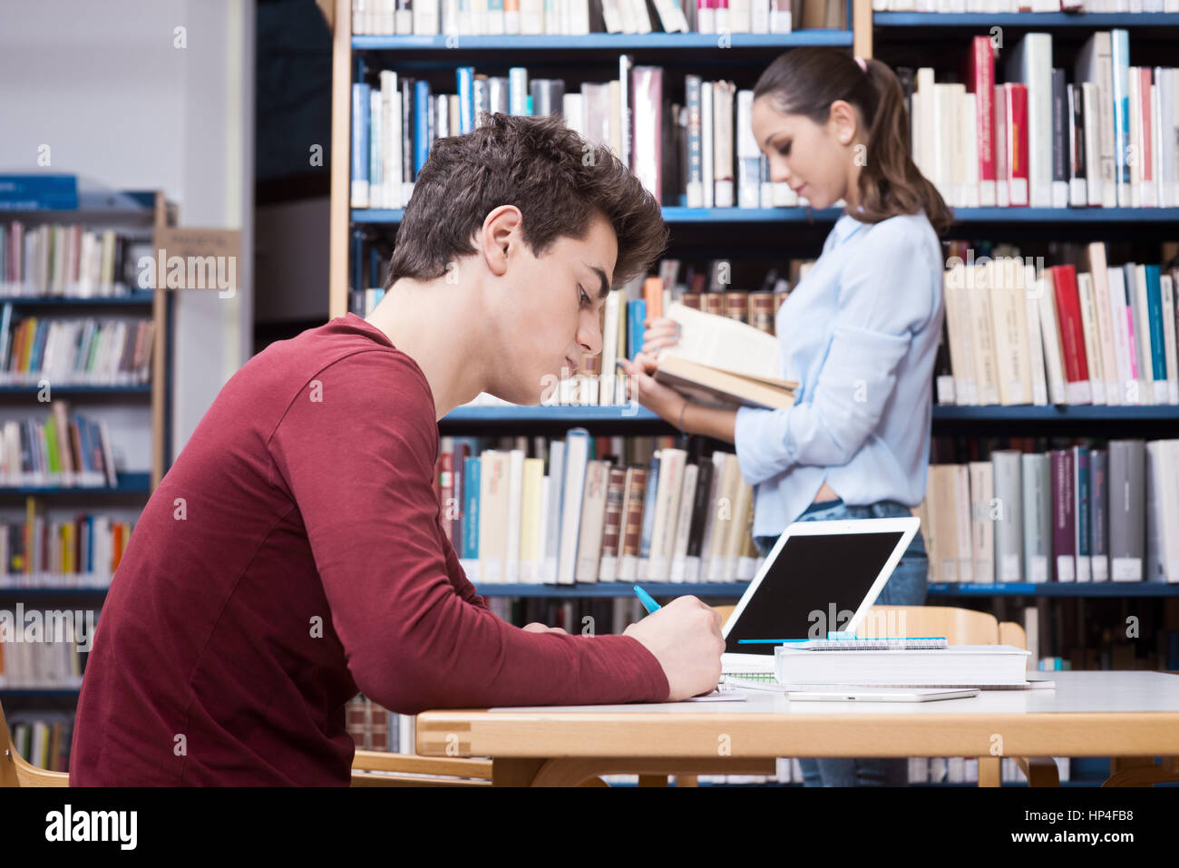 Young student studying at the library, girl and bookshelves on ...