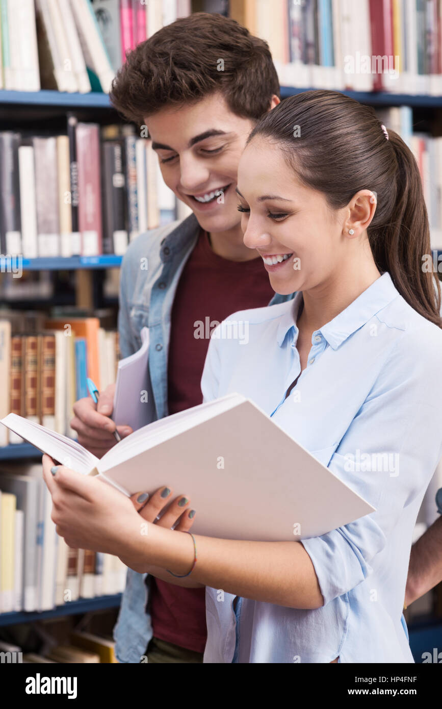 Teenager students at the library studying together with books Stock ...