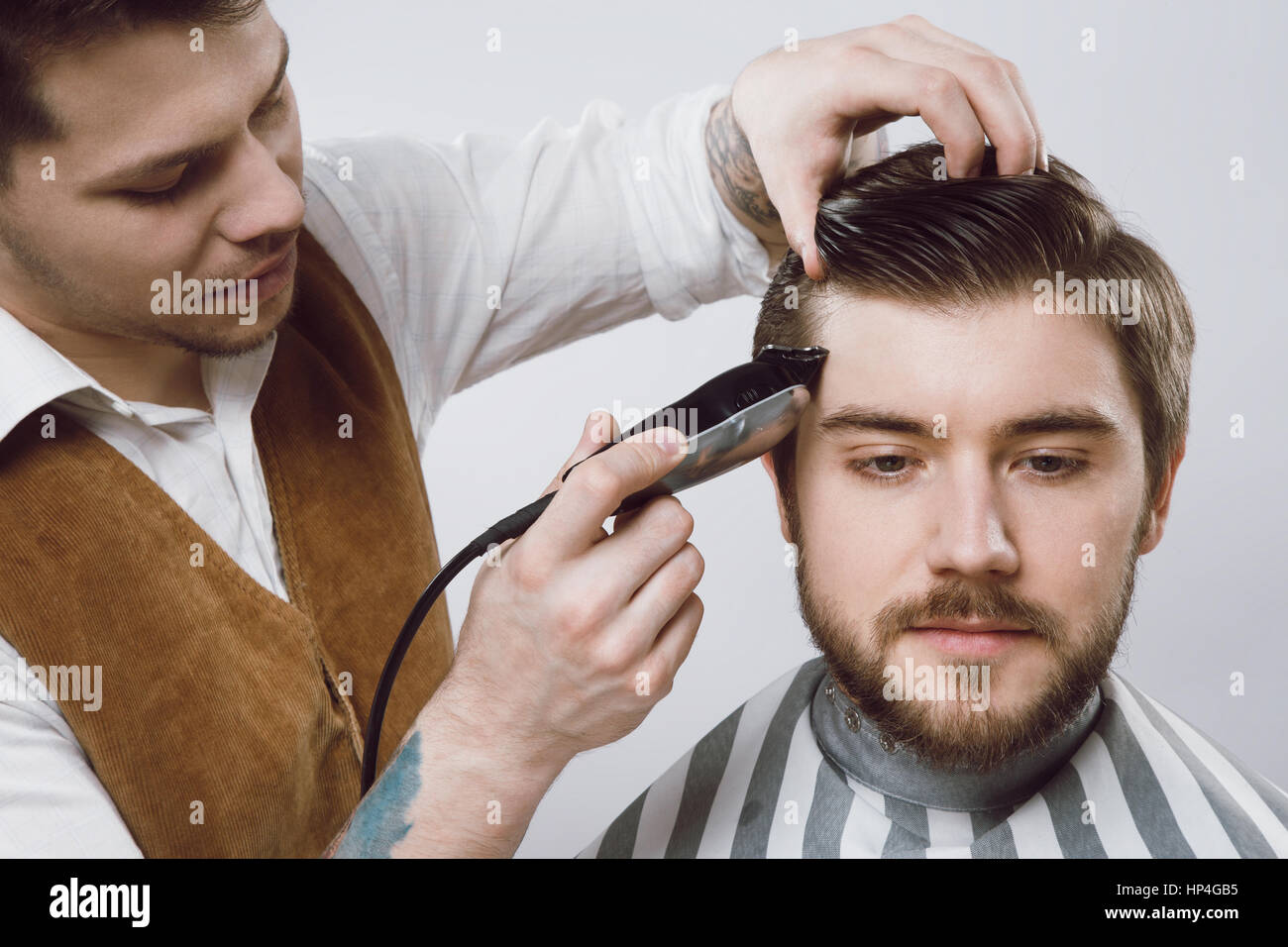 Attractive barber doing haircut Stock Photo - Alamy