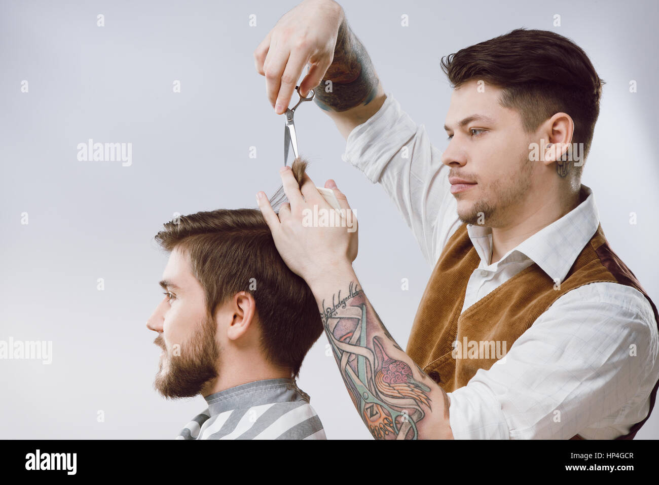 Attractive barber doing a haircut Stock Photo - Alamy