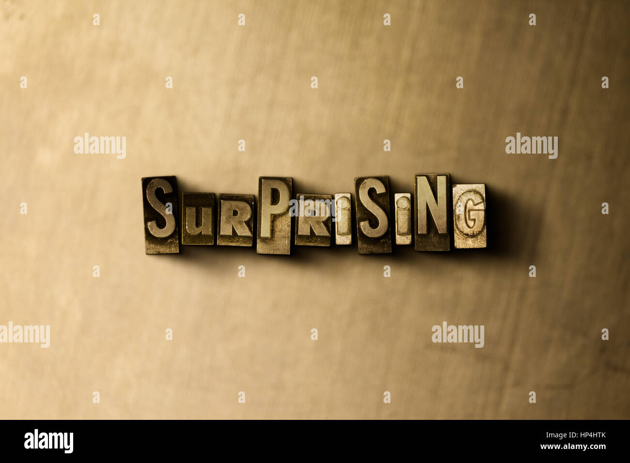 SURPRISING - close-up of grungy vintage typeset word on metal backdrop ...
