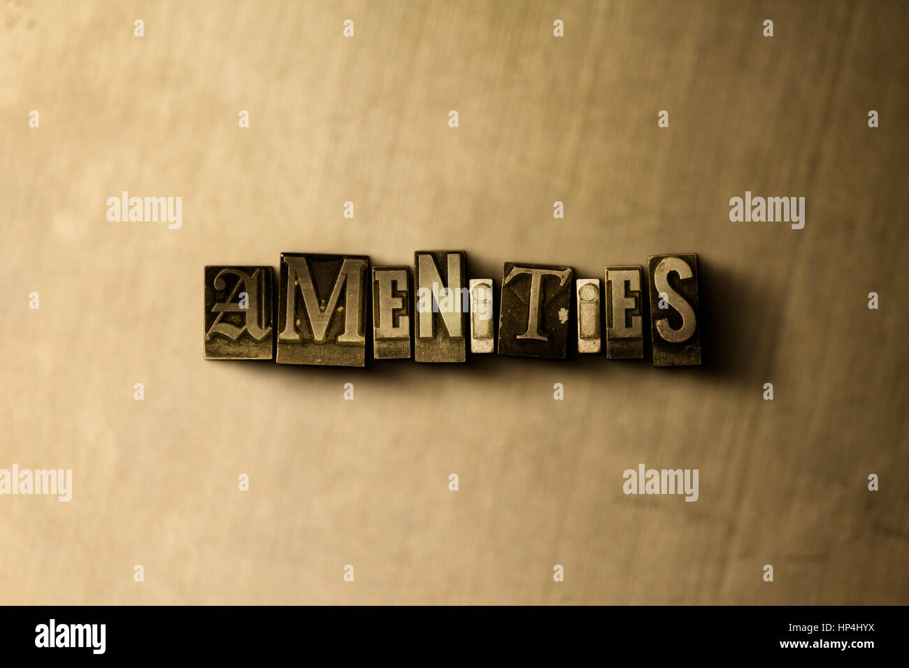 AMENITIES - close-up of grungy vintage typeset word on metal backdrop ...