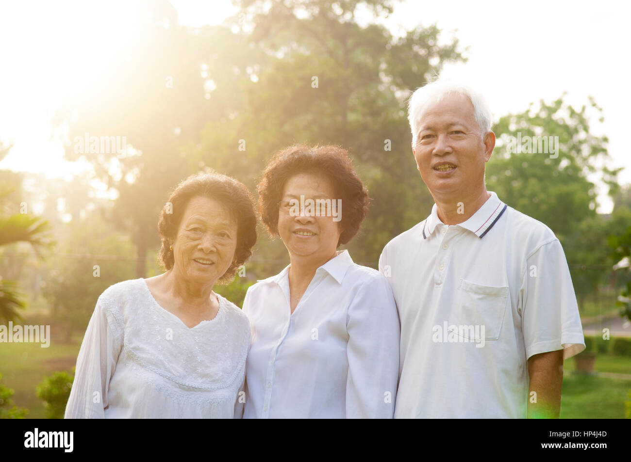 Group of healthy Asian seniors having good time at outdoor nature park ...