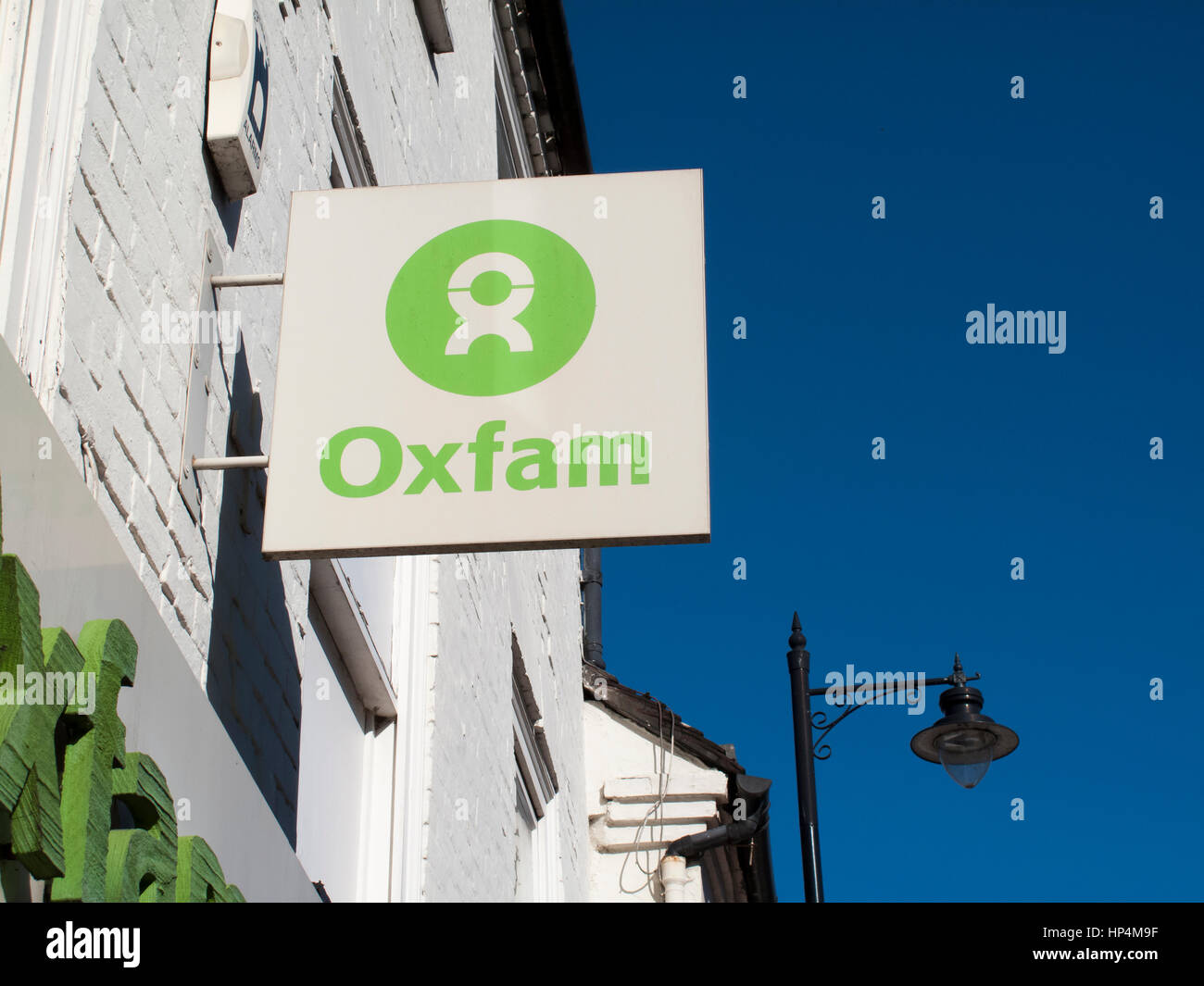 Oxfam charity shop sign over retail store, finding solutions to poverty ...
