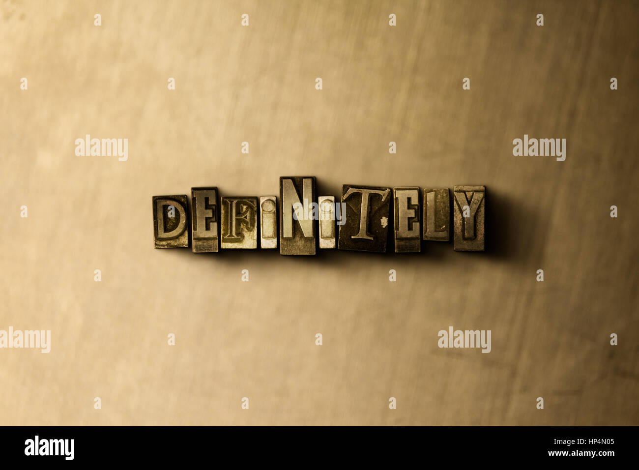 DEFINITELY - close-up of grungy vintage typeset word on metal backdrop ...
