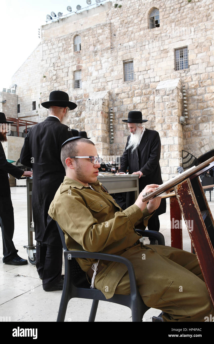 jewish soldier reading a book at western wall. old city, jerusalem ...