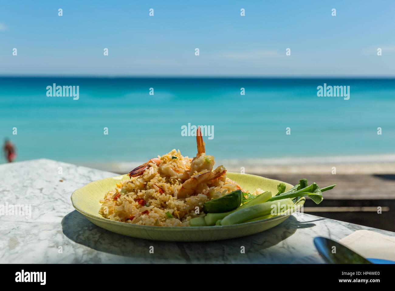 Plate of rice with prawns on sea background Stock Photo - Alamy
