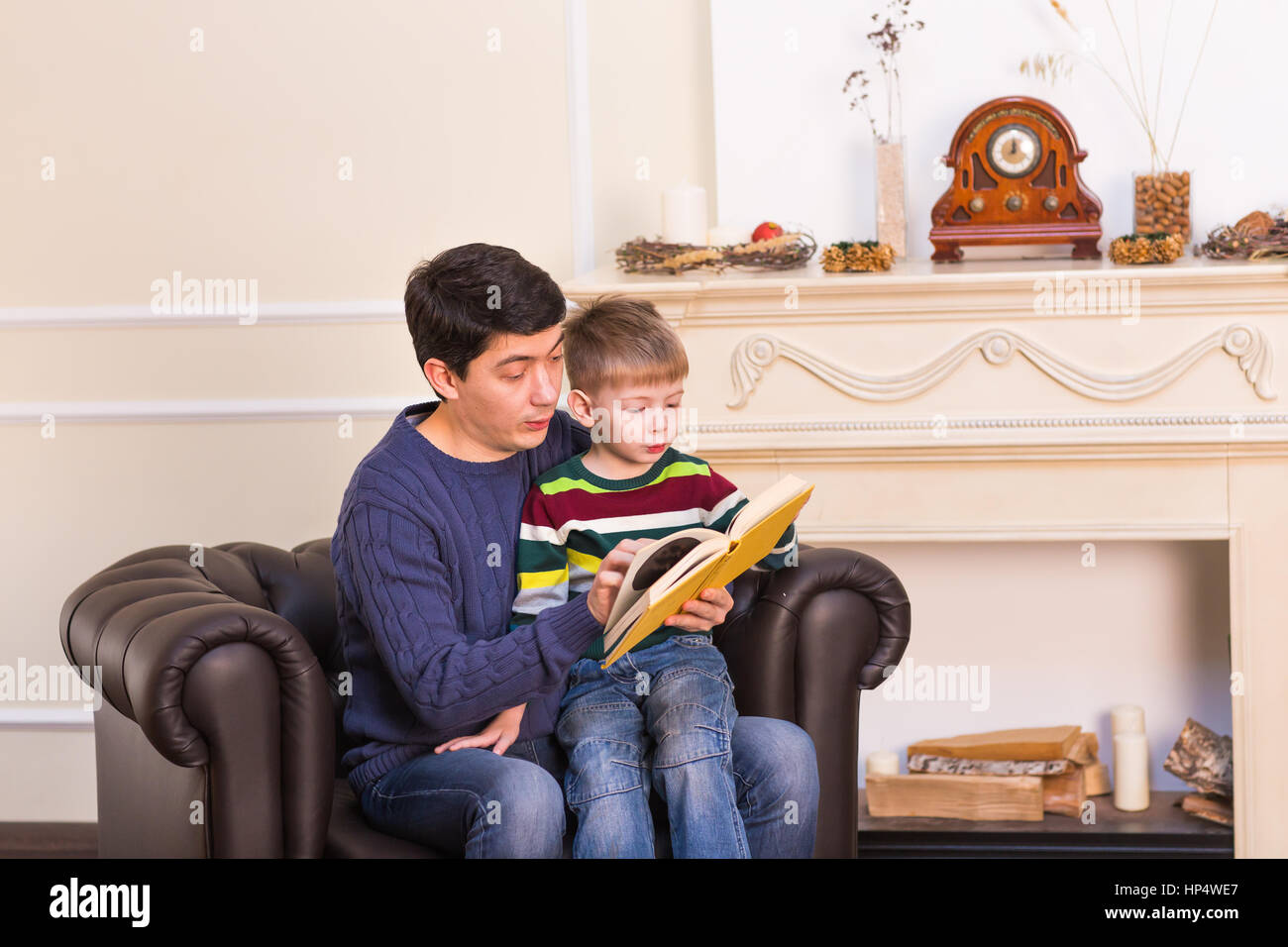 Father and son reading story book together Stock Photo - Alamy