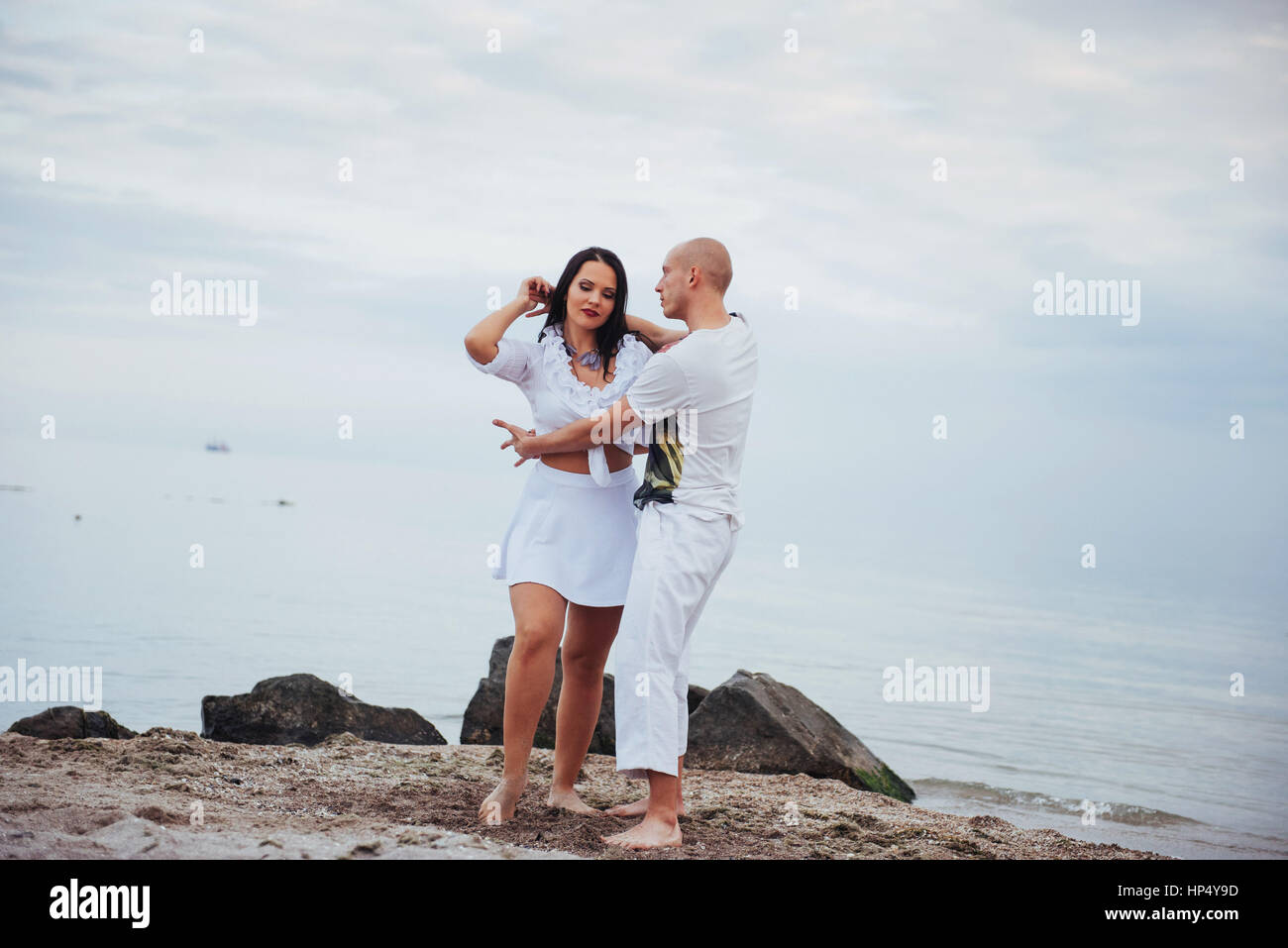 Beautiful inflammatory couple dancing on the beach Stock Photo - Alamy