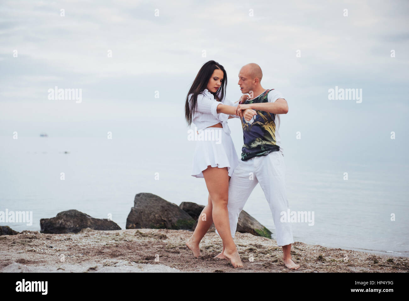 Beautiful inflammatory couple dancing on the beach Stock Photo - Alamy