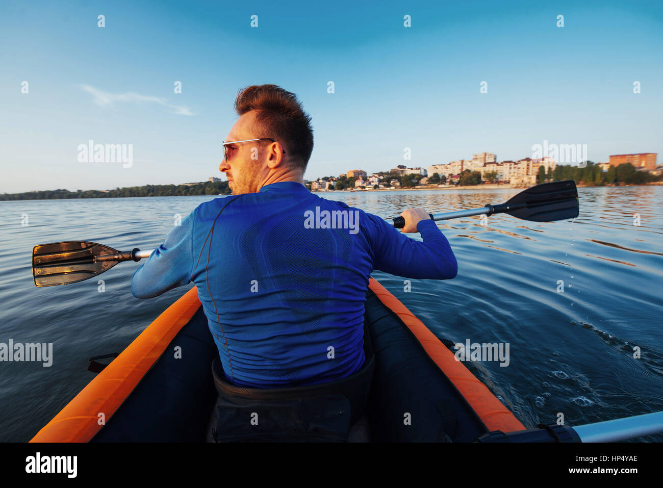 man floating on lake in a kayak at fantastic sunset Stock Photo - Alamy