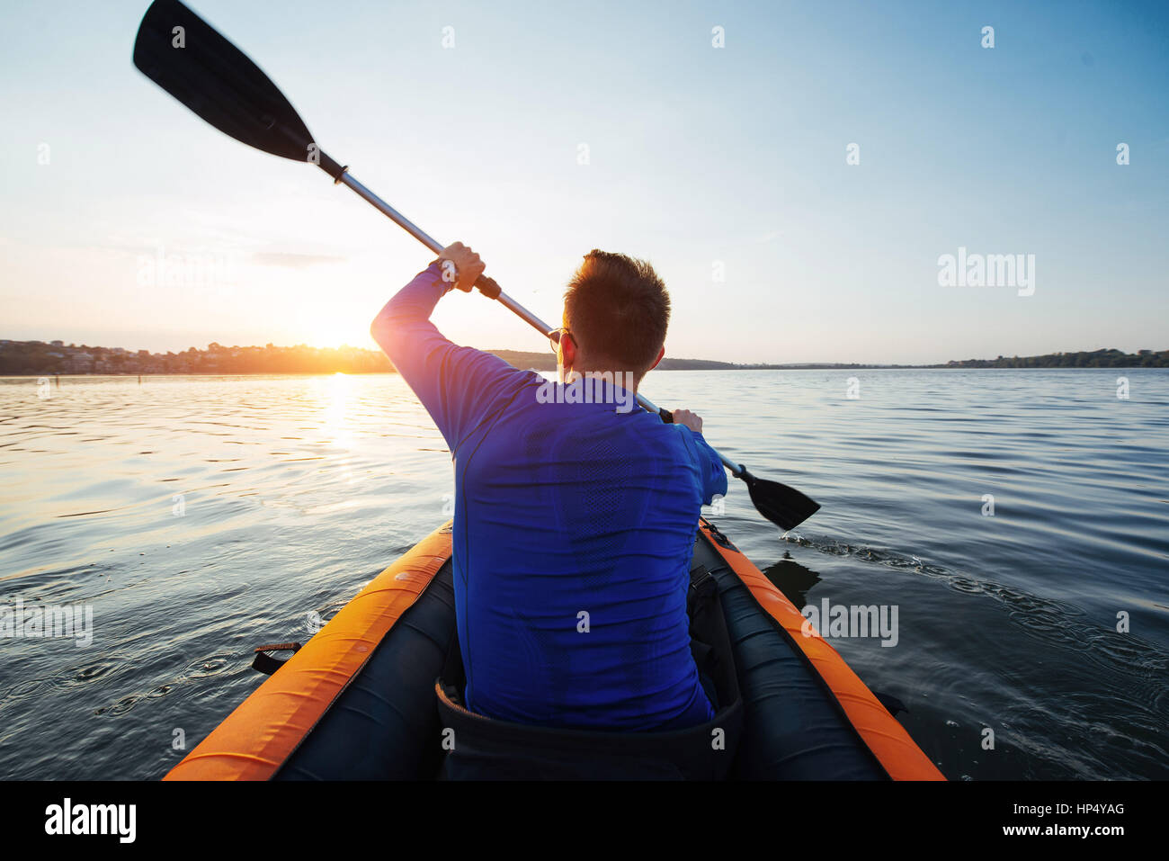 man floating on lake in a kayak at fantastic sunset Stock Photo - Alamy